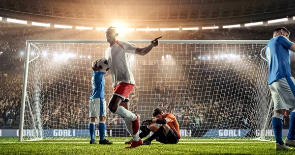 Attacker scores a goal, sending a ball past defenders and a goalkeeper ...