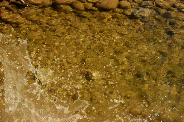 The river flows over the stones in a cascade, a huge stone fell into ...