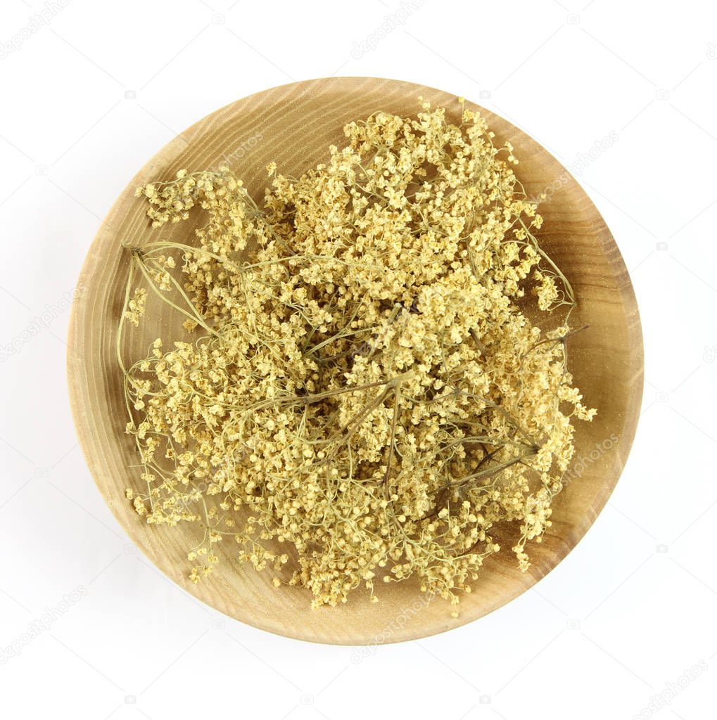 Bayas de saúco secas, sambucus nigra, en cuenco de madera aislado sobre ...