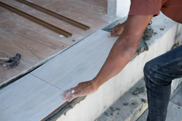 Workers hands with ceramic tiles. Floor tiles installation. Home ...