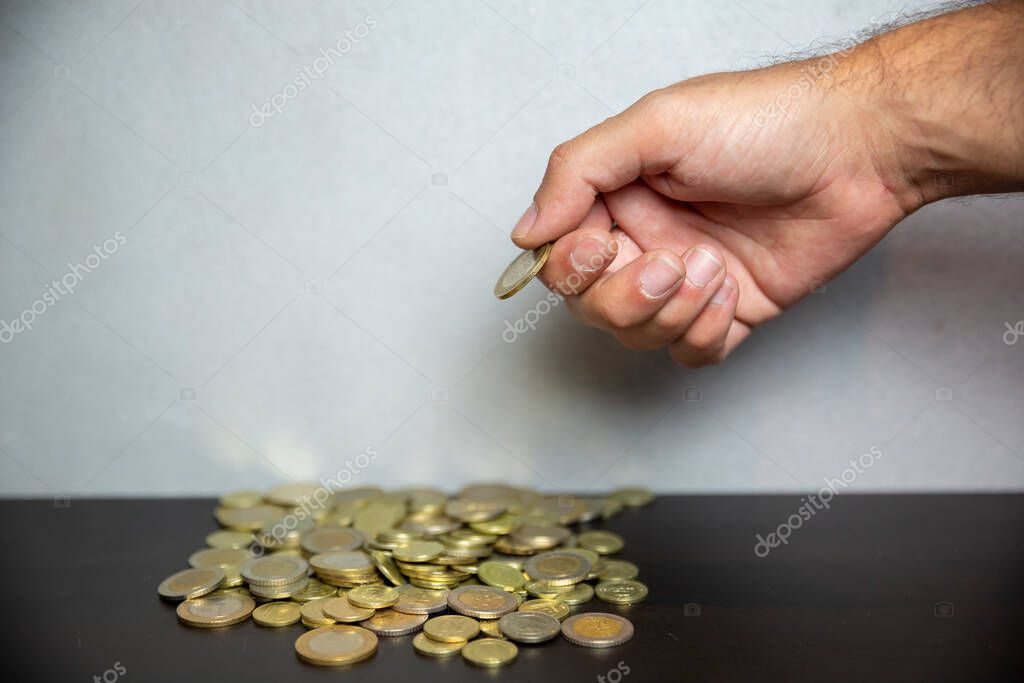 Man hand holding coin, selective focus #392867304 - Larastock