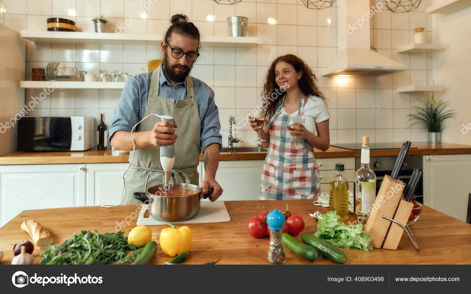 Italian man, chef cook using hand blender, preparing a meal while his ...