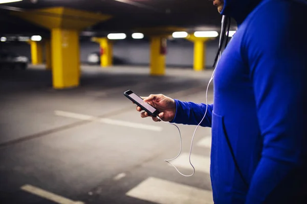 Man setting workout playlist on a mobile phone. - Stock Image - Everypixel