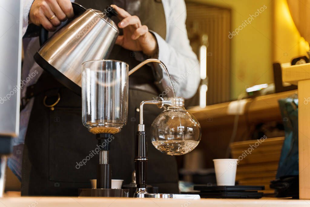Syphon método alternativo de hacer café. Barista vierte agua hirviendo ...