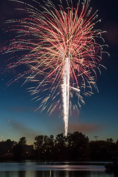 Vibrant firework explosions in the night sky at dusk. - Stock Image ...