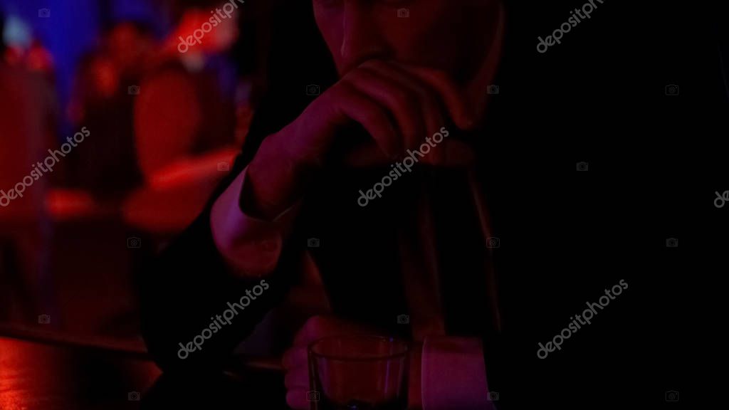 Hombre desesperado bebiendo demasiado alcohol solo en el bar, problemas ...