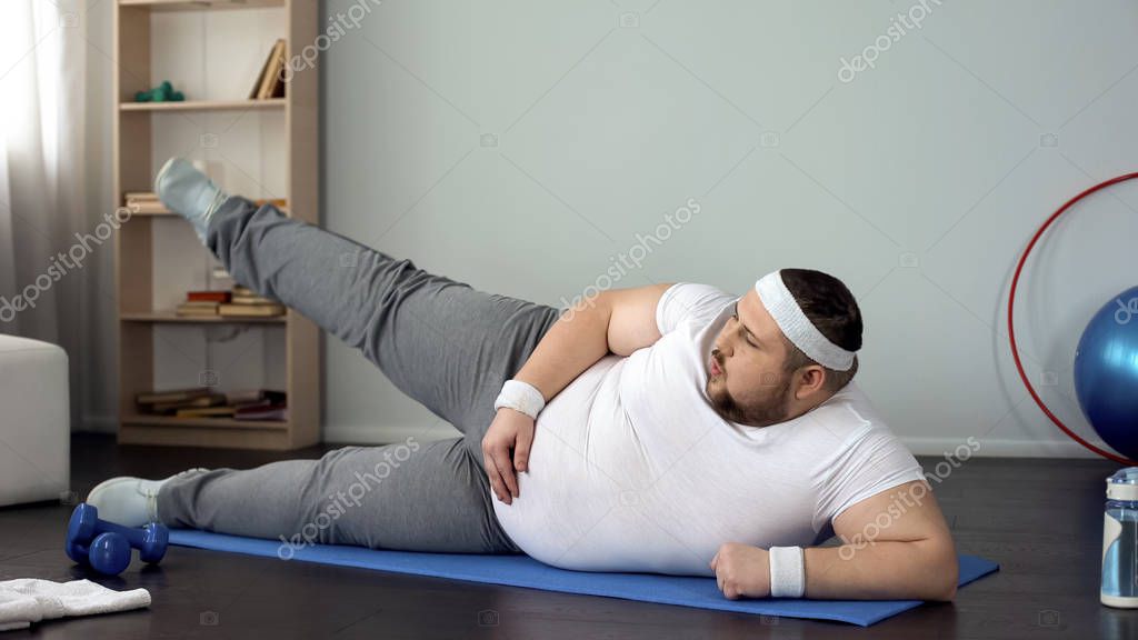 Hombre obeso levantamiento de piernas acostado en la estera, estilo de ...