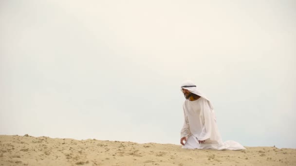 Arab raising hands to heaven, praying on knees, asking Allah to forgive ...