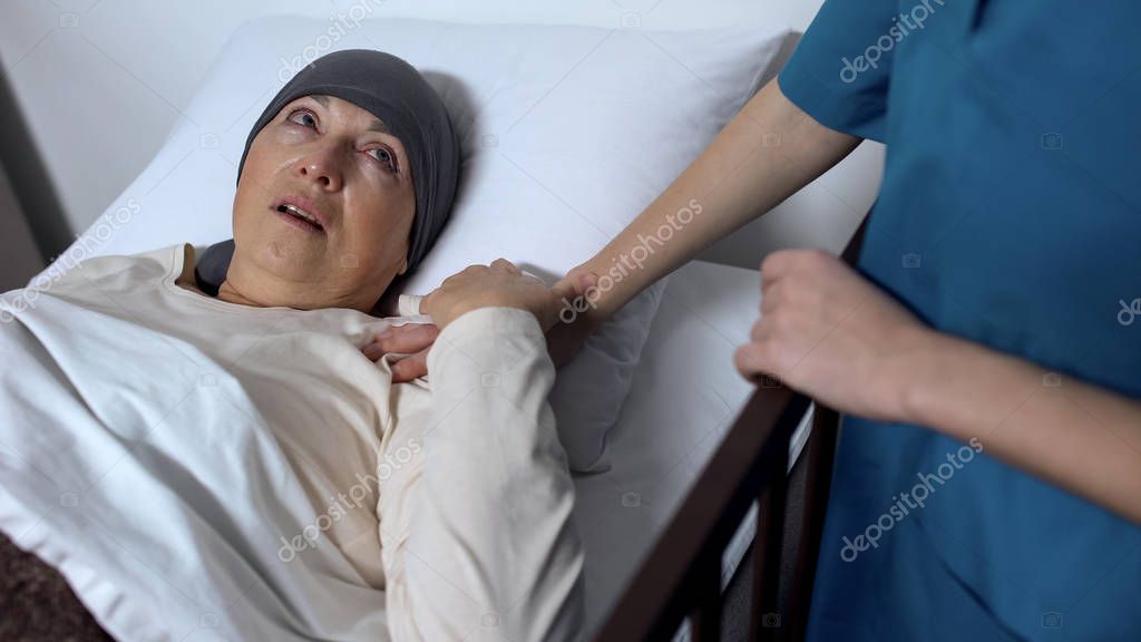 Médico que apoya al paciente solitario enfermo terminal, cogido de la ...