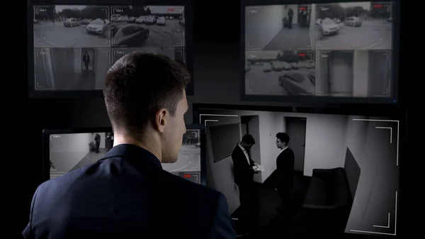 Security guard conducting surveillance by watching several secur ...