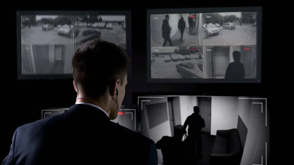 Security guard conducting surveillance by watching several secur ...