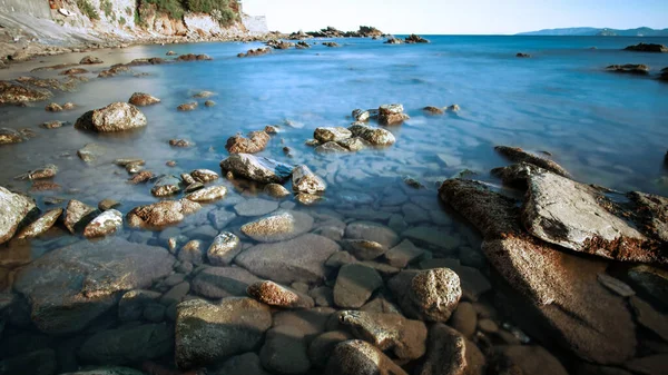 Rocky coast bay of mediterranean sea. Water on long exposure. Sunlight ...