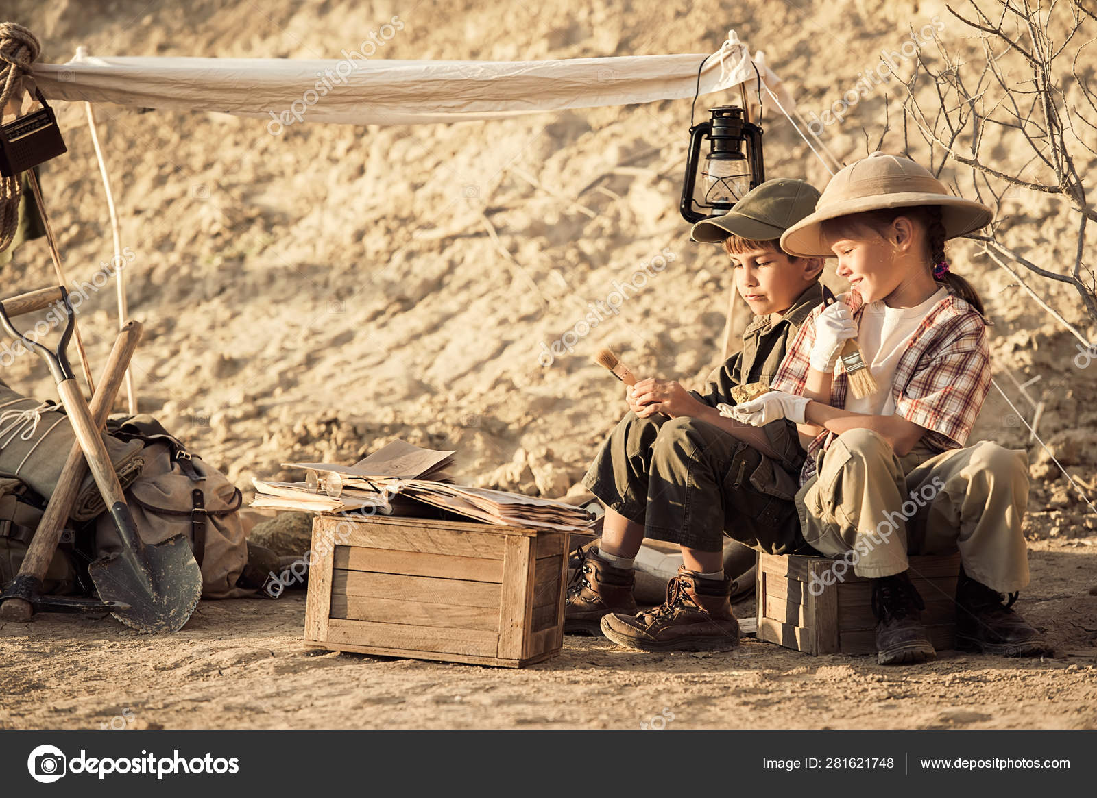 Children archaeologists take notes in a notebook on the excavations ...