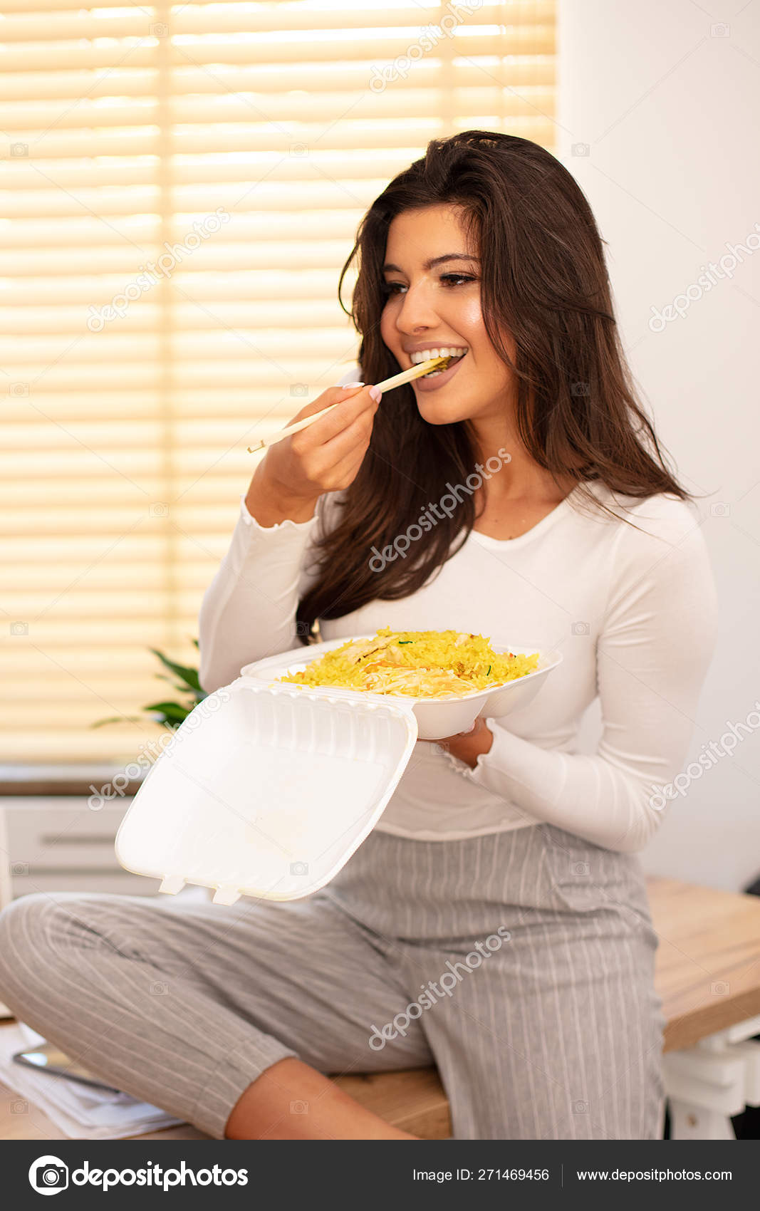 Female office worker eating Asian food from takeaway box. Stock Photo ...