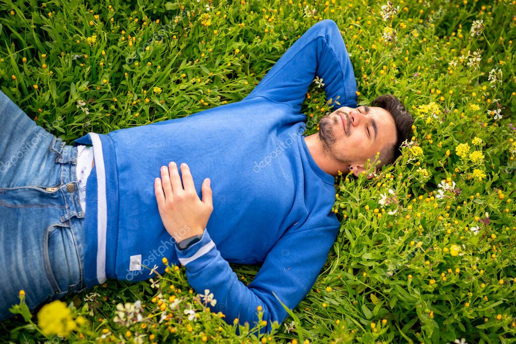 joven acostado en un campo de flores amarillas. disfrutar de la ...