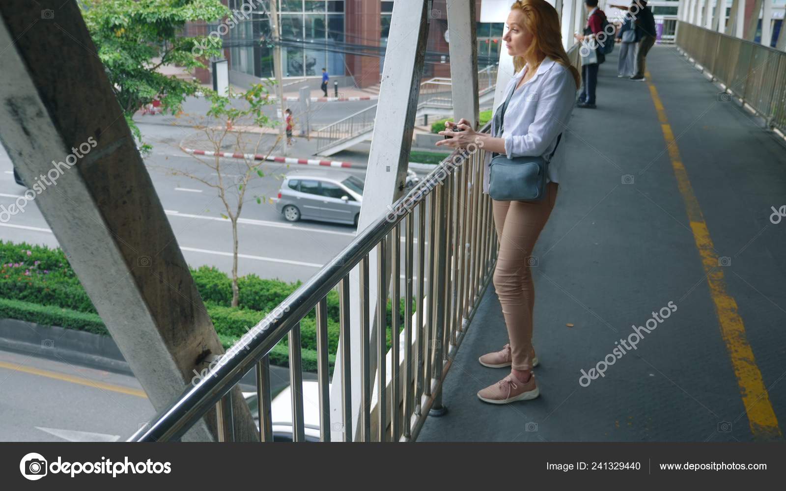 A woman with a camera walks through the streets of a large modern city ...