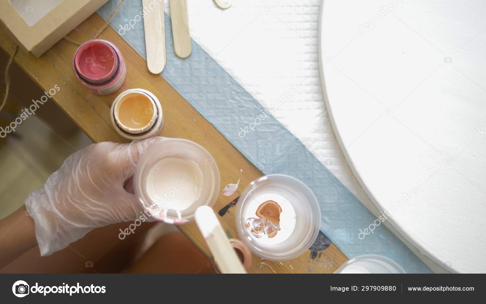 Close-up, mixing paint in a disposable cup. artists workplace ...