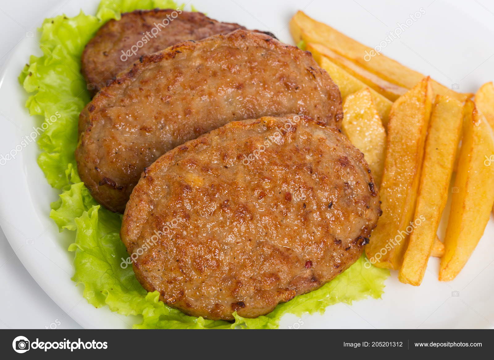 Three fried breaded cutlet with tomatoes and french fries on white ...