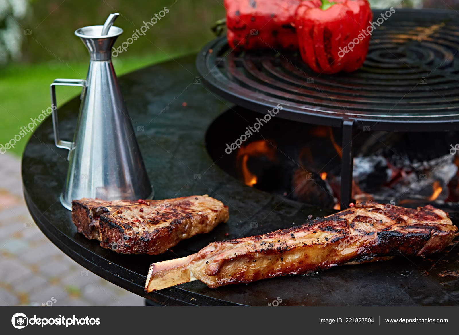 Tomahawk rib beef steak and T-bone on hot black grill. Stock Photo by ...