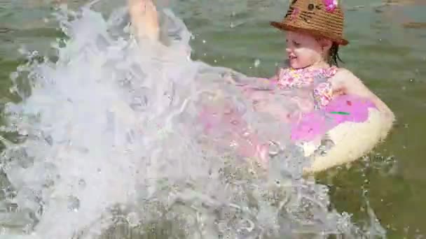 Child in the inflatable circle. A happy girl splashes in an inflatable ...