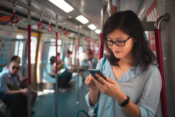 Woman using smartphone in train - Stock Image - Everypixel