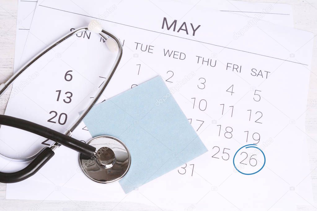 Estetoscopio en la página del calendario. Concepto de examen médico ...