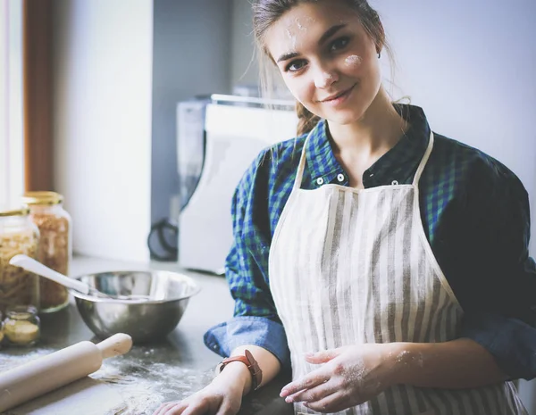 Beautiful woman cooking cake in kitchen standing near desk — Stock ...