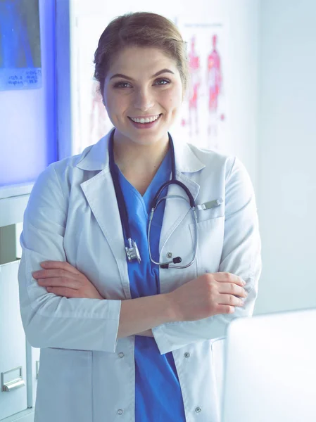 Young woman medic in white uniform standing in clinics office - Stock ...