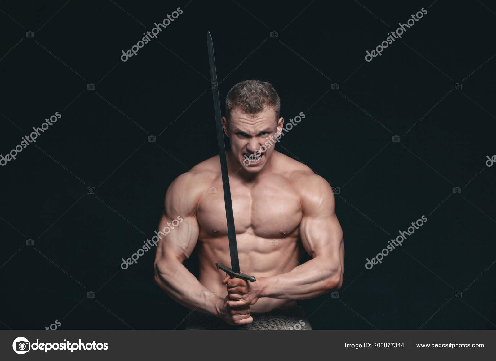 Bodybuilder man posing with a sword isolated on black background ...