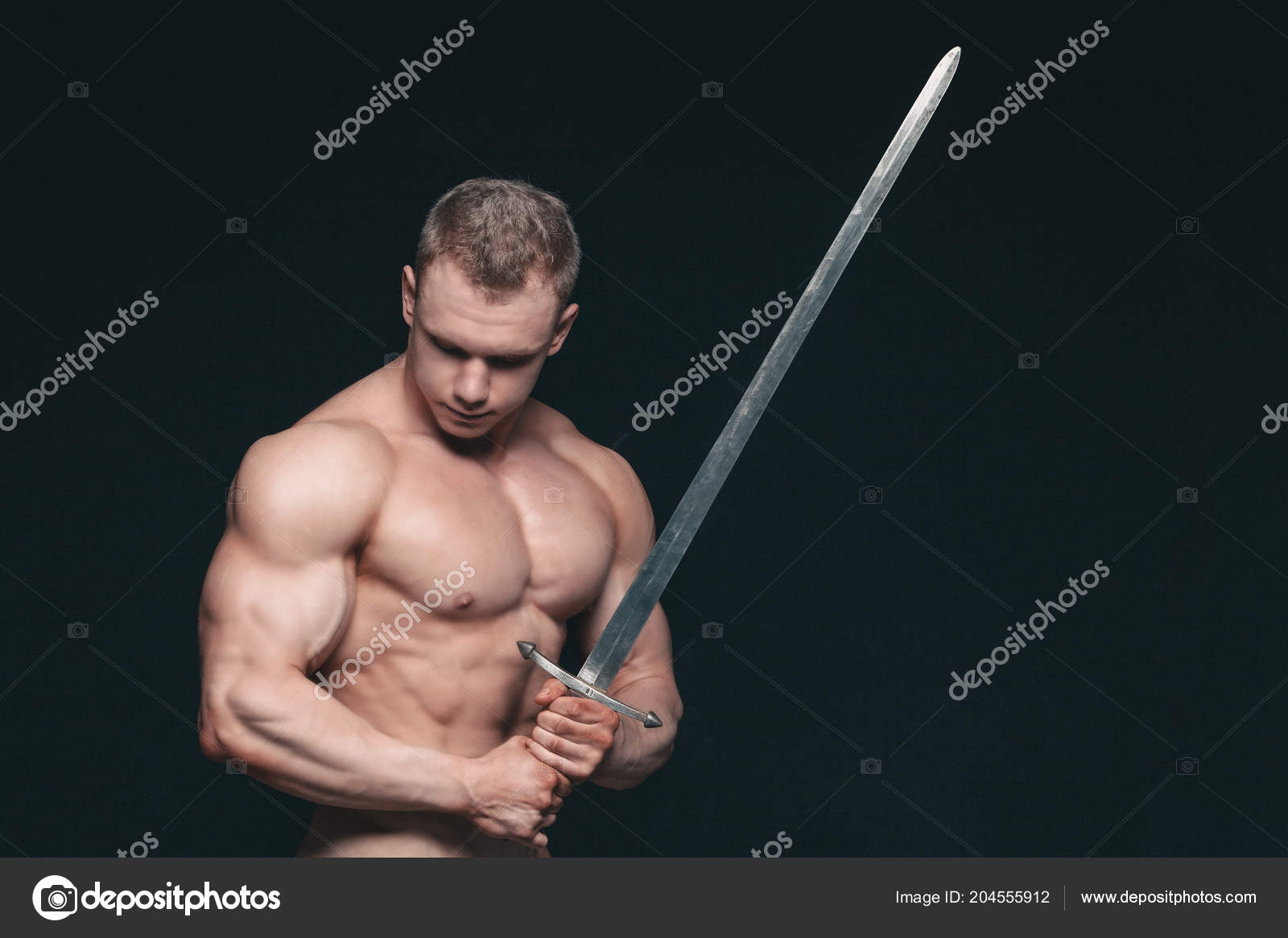 Bodybuilder man posing with a sword isolated on black background ...