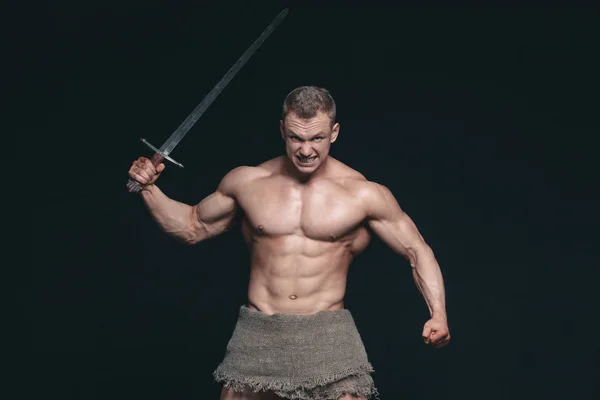 Bodybuilder man posing with a sword and shield isolated on white ...