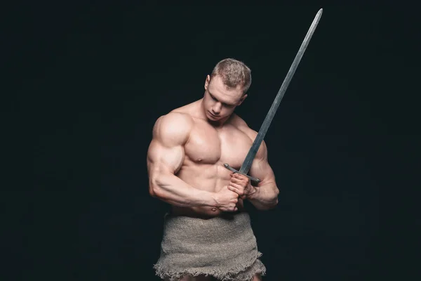 Bodybuilder man posing with a sword and shield isolated on white ...