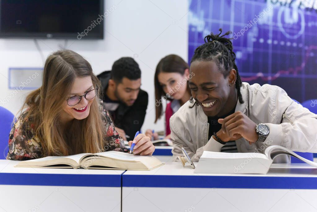 Jóvenes estudiantes mirando los libros. Aprendiendo en el aula moderna ...