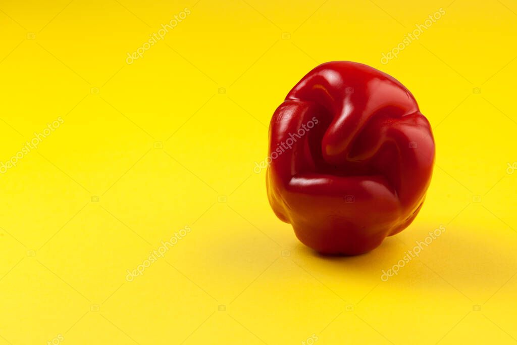 Pimiento rojo feo sobre fondo amarillo con espacio para copiar ...