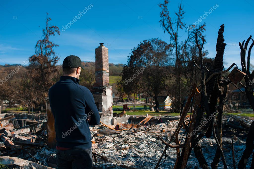 El dueño del hombre revisando la casa quemada y arruinada y el patio ...