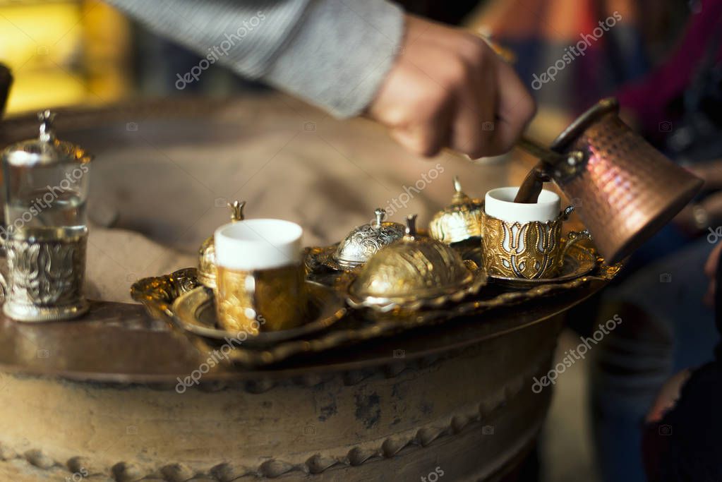 Sirve café turco que cocinó en arena caliente de un cezve de cobre a ...