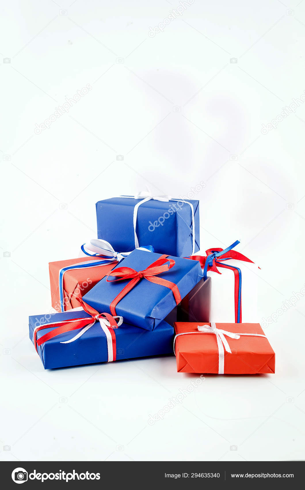 Red, blue and white gift boxes with ribbons on a white backgroun ...