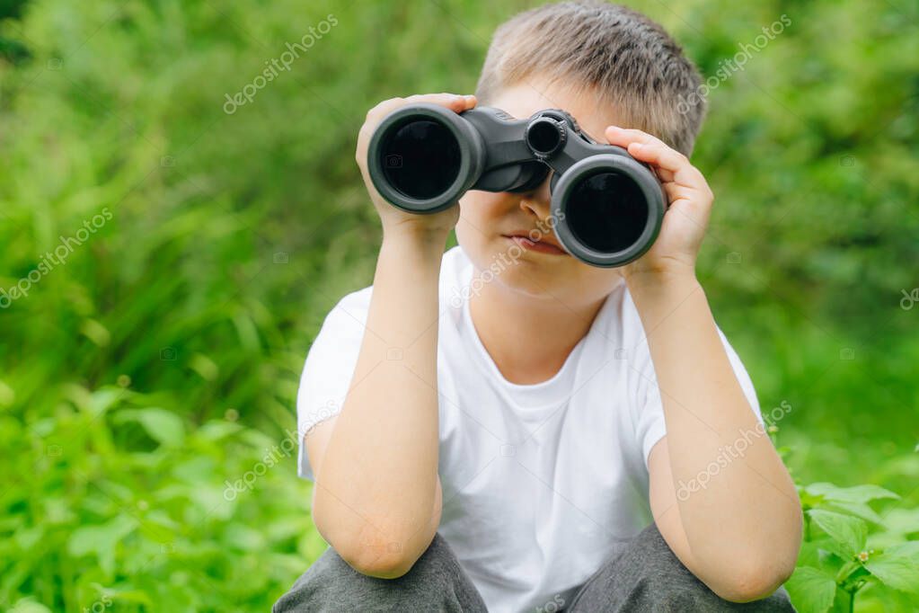 curioso niño busca vida silvestre a través de prismáticos en el parque ...