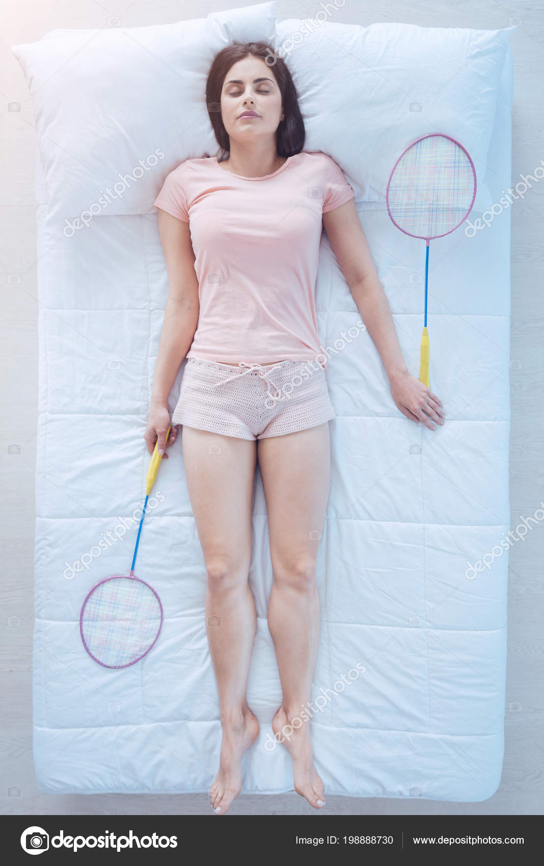 Exhausted young lady having rest with badminton rackets — Stock Photo ...