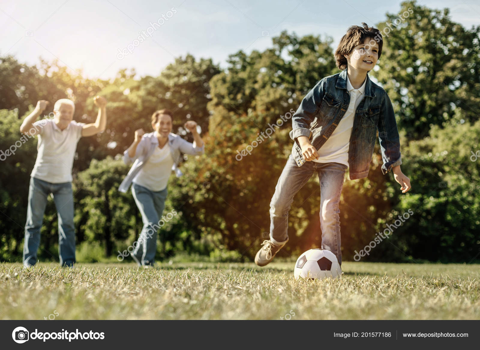 Boy playing the ball and his family supporting him Stock Photo by ...