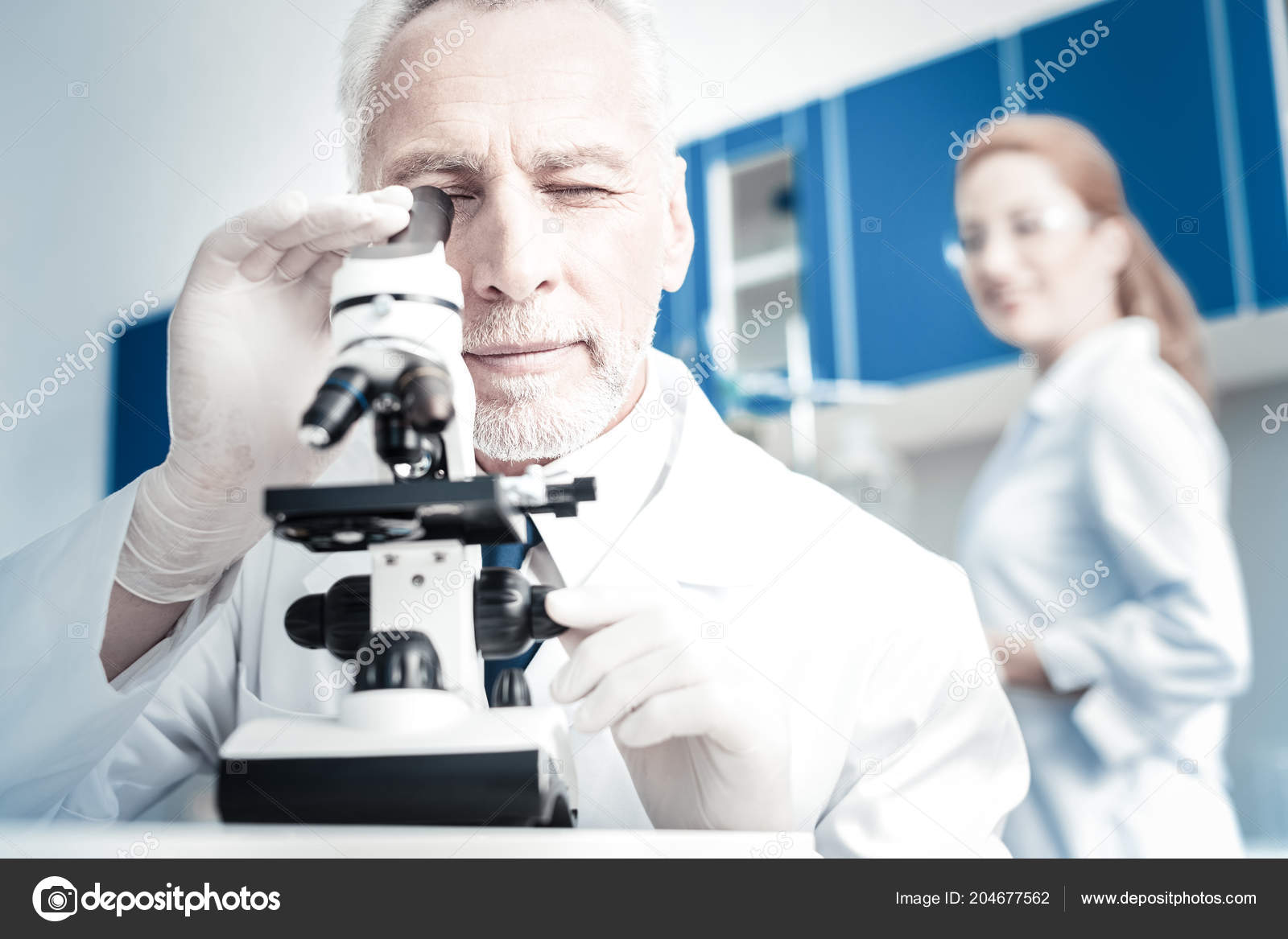 Smart handsome biologist looking into the microscope — Stock Photo ...