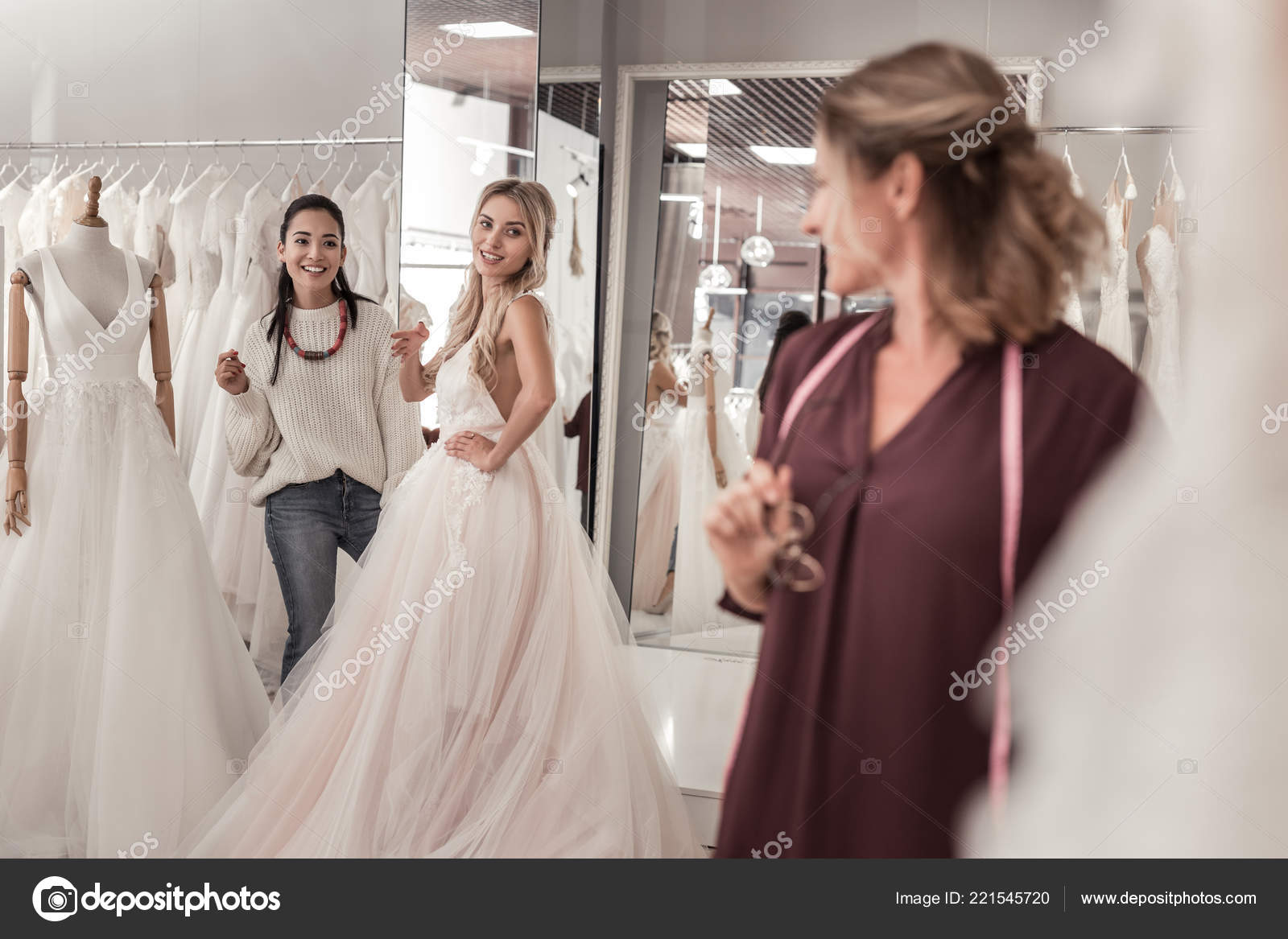 Joyful young women looking at the wedding dress designer Stock Photo by ...