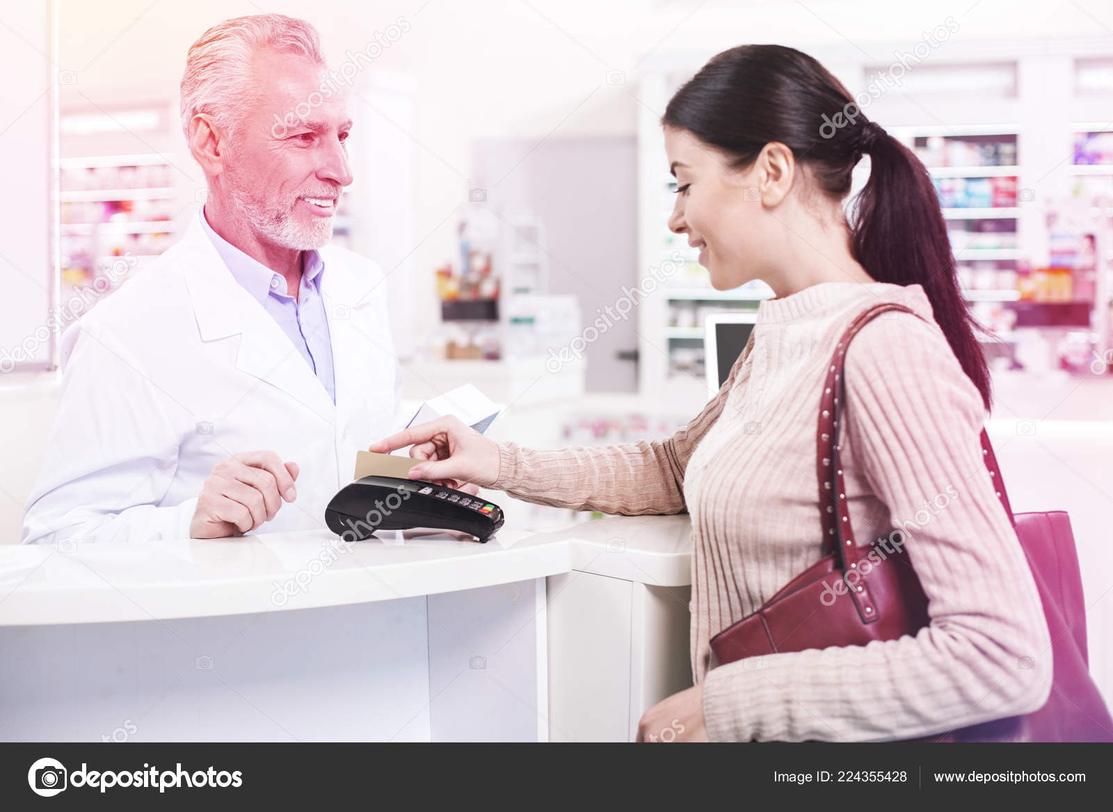Beaming woman using a credit card paying for her medication — Stock ...