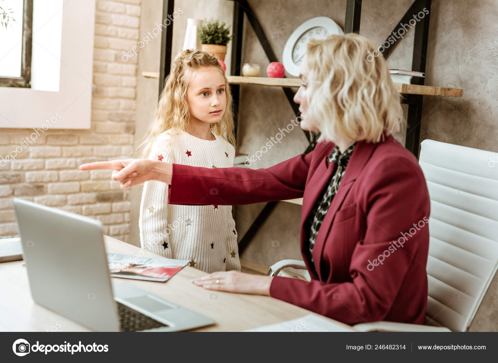 Angry strict mother pointing on exit while her little daughter ...