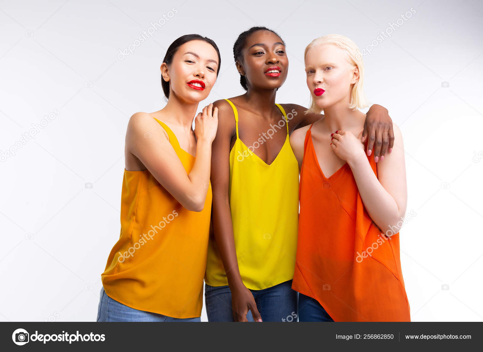 Women with different skin wearing jeans and colorful blouses Stock ...