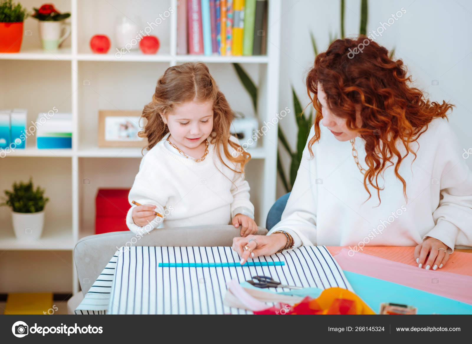 Girl helping mom sketching designs for new collection Stock Photo by ...