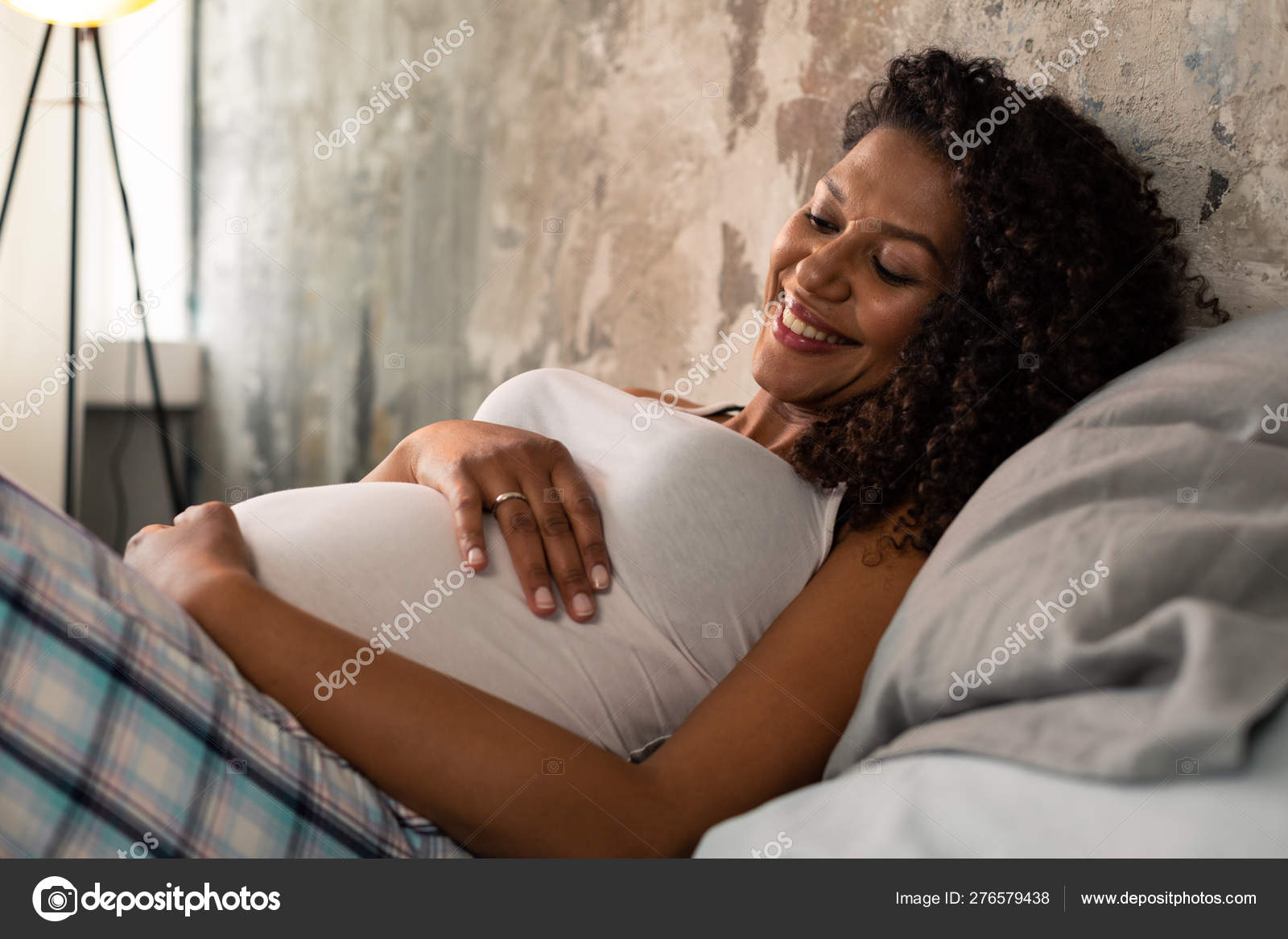 Hermosa mujer embarazada sonriente tocando su vientre . — Foto de stock © yacobchuk1 #276579438