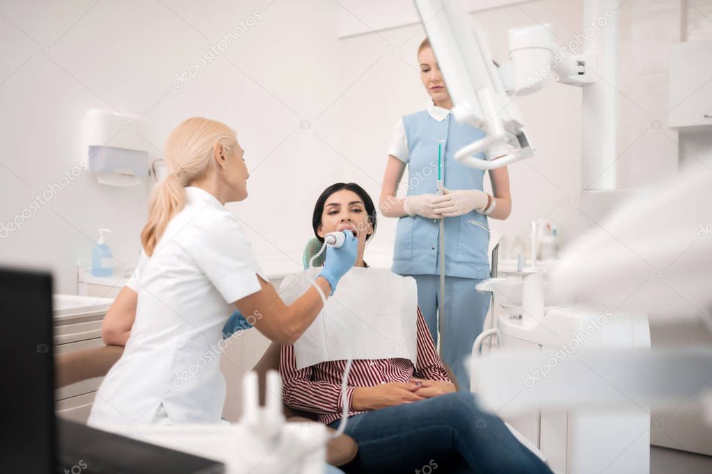 Dentista y su asistente cuidando a su paciente. 2024