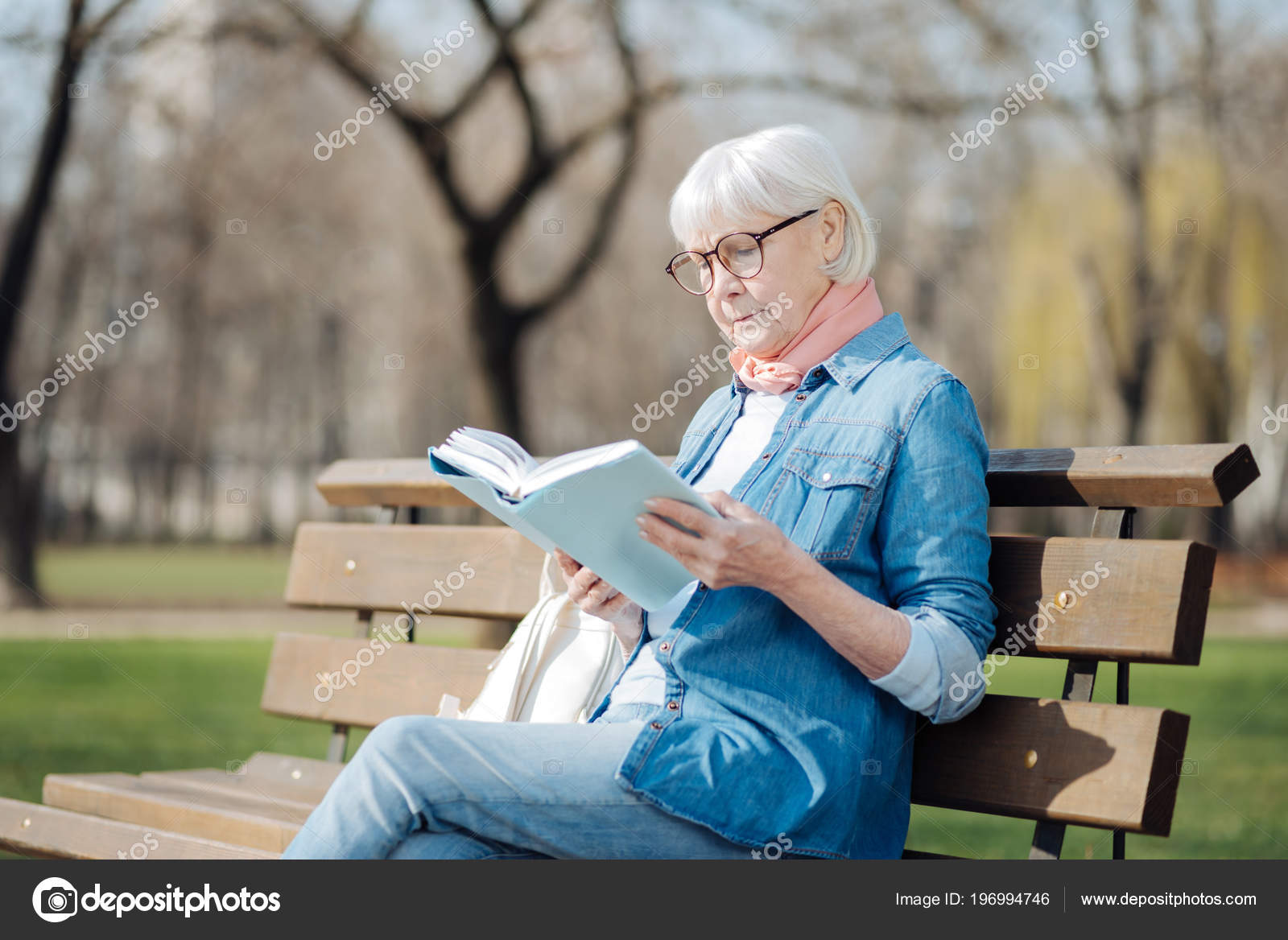 Concentrated old woman reading a book Stock Photo by ©Dmyrto_Z 196994746