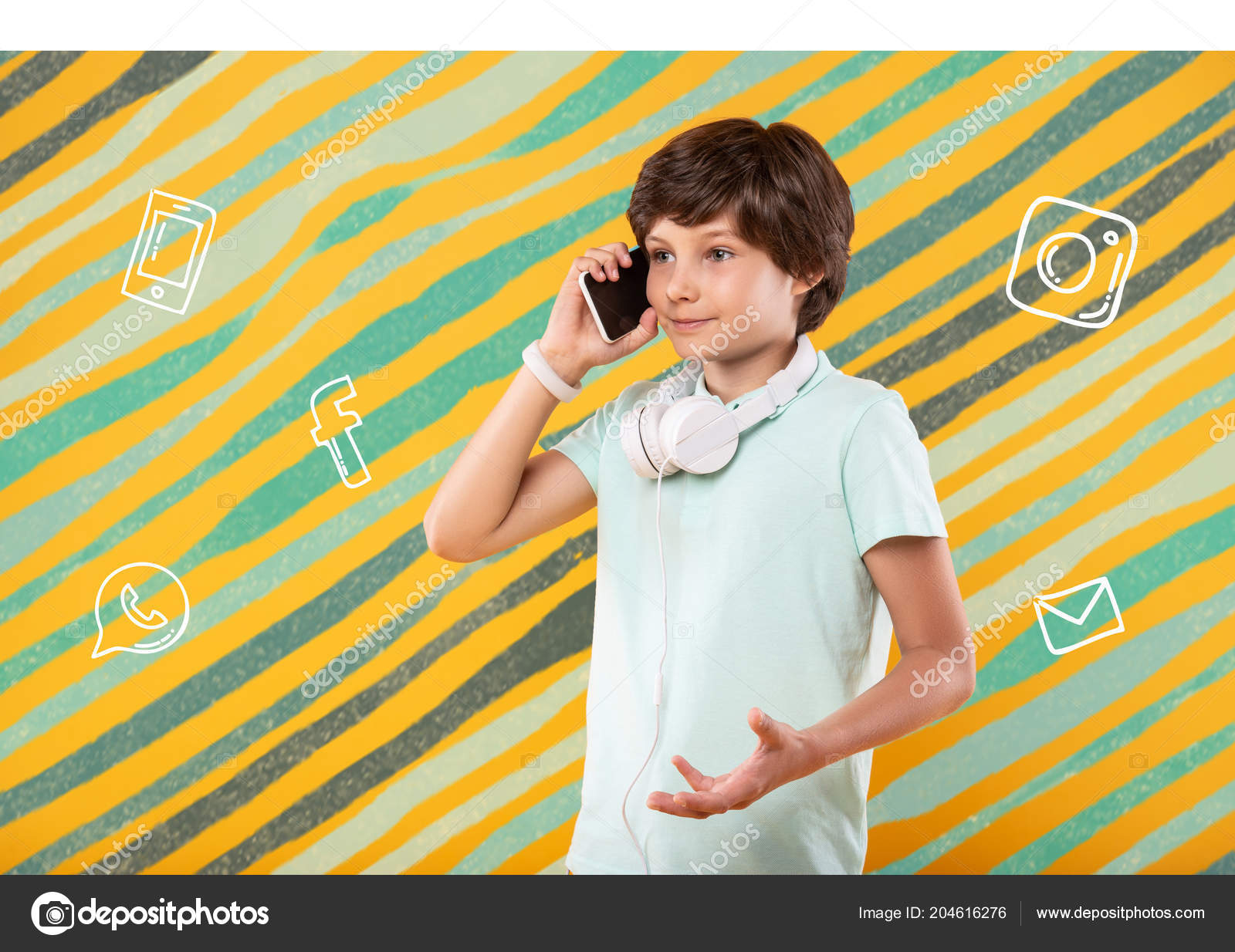 Cheerful boy talking to a friend on the phone and looking interested ...